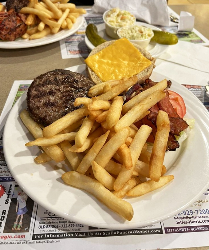 A burger that means business, surrounded by a golden moat of perfectly crisp fries. The kind of meal that requires a nap afterward.