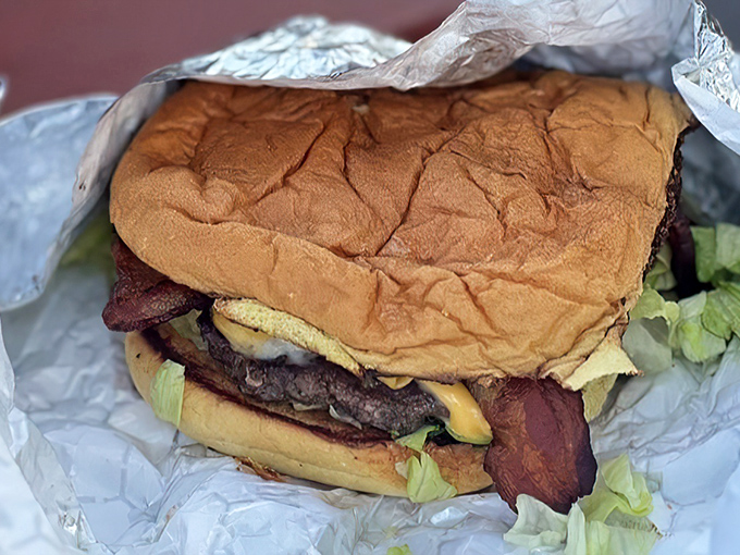 A burger that requires both hands, a stack of napkins, and absolutely zero regrets. Diet plans were made to be broken by this beauty.