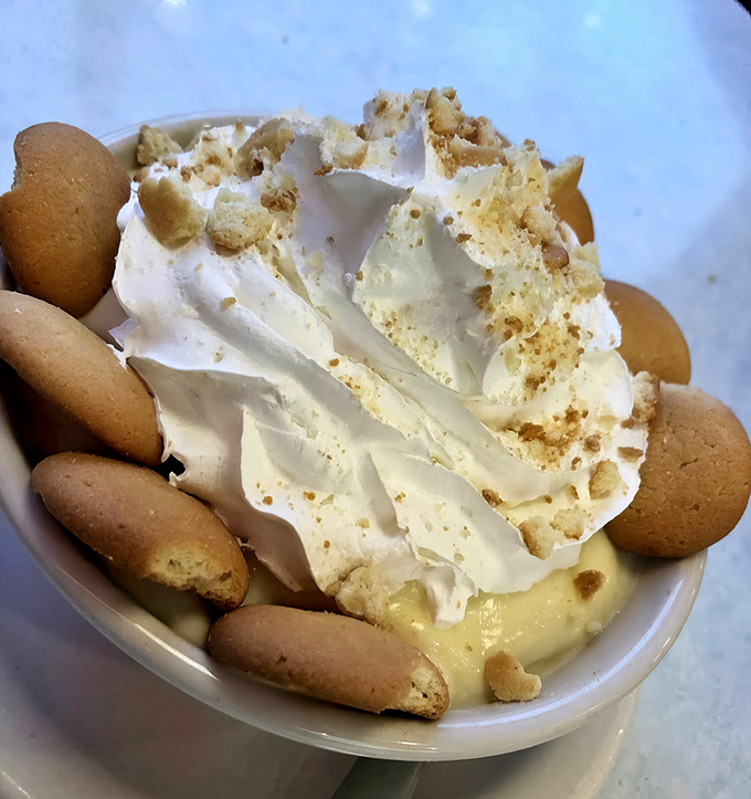 Banana pudding that would make your grandmother simultaneously proud and jealous, crowned with a cloud of whipped cream.