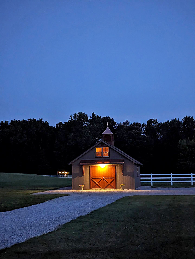 As darkness falls, the barn's warm glow becomes a lighthouse on land, beckoning weary travelers home after a day of rural adventures.