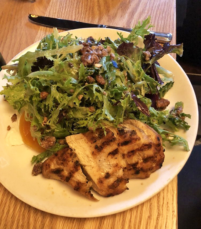 A salad that actually excites&mdash;grilled chicken alongside vibrant greens and what appears to be candied nuts, proving healthy can be heavenly.
