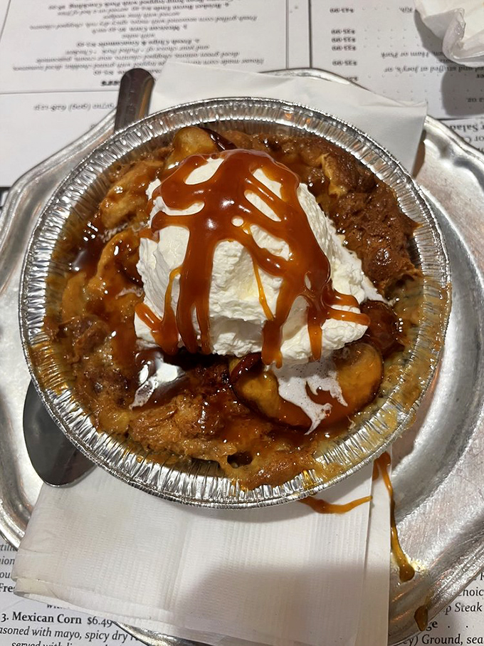 Apple bread pudding topped with whipped cream and caramel &ndash; because after a barbecue feast, your sweet tooth deserves its moment too.