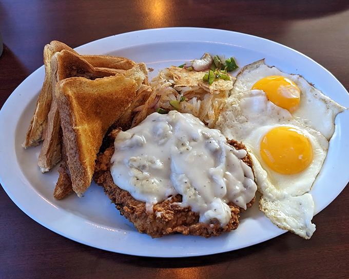 Country fried steak with eggs&mdash;where crispy, peppery coating meets creamy gravy in a breakfast that fuels Indiana's hardworking souls through anything life throws their way.