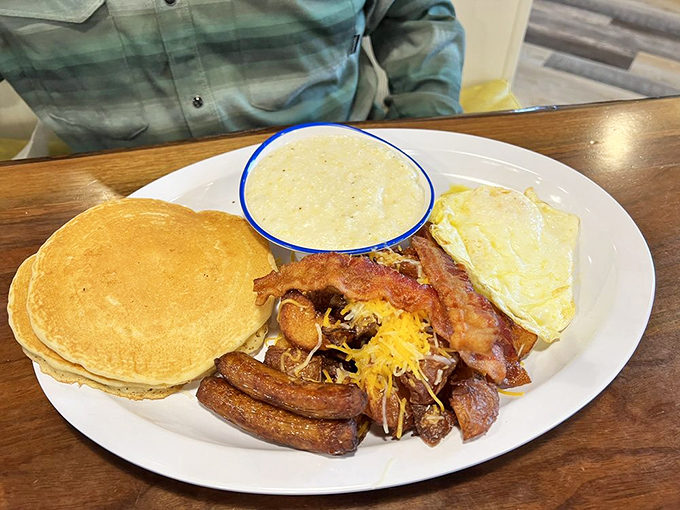 The breakfast plate that launched a thousand road trips. Golden pancakes, eggs, bacon, sausage, and grits&mdash;the breakfast equivalent of a greatest hits album.