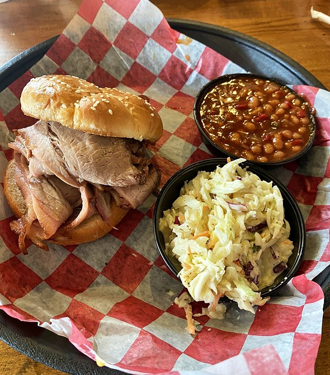 The holy trinity of barbecue happiness: a sandwich that requires both hands, beans with purpose, and slaw that knows its role.