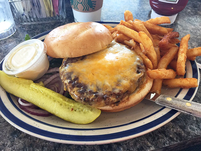 A cheeseburger that doesn't need Instagram filters – just honest beef, melted cheese, and a pickle standing guard.