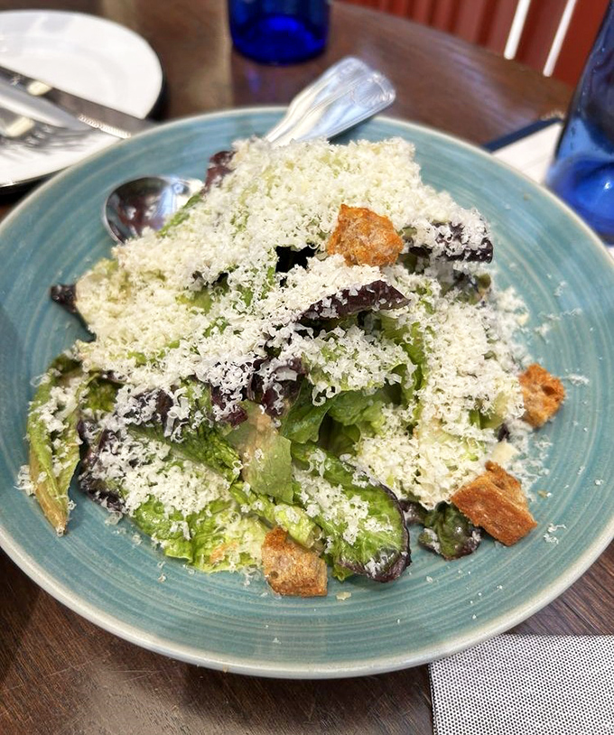 That Caesar salad is buried under enough Parmesan to make any Italian grandmother nod with approval and maybe shed a tear.