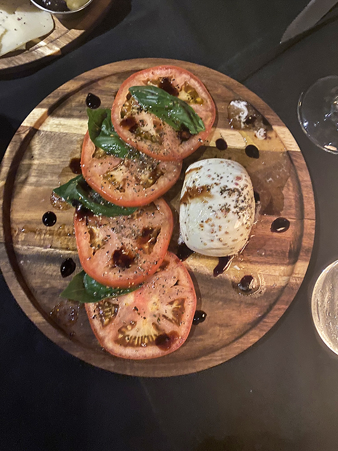 The Caprese salad arrives like edible artwork&mdash;ripe tomatoes, fresh basil, and mozzarella drizzled with balsamic on a rustic wooden board that screams "Instagram me!"