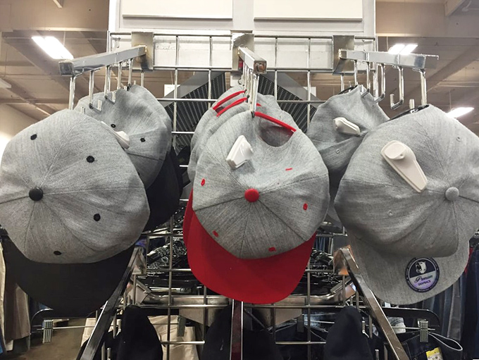 Baseball caps hanging like patient sentinels, waiting for second chances and new heads to call home.