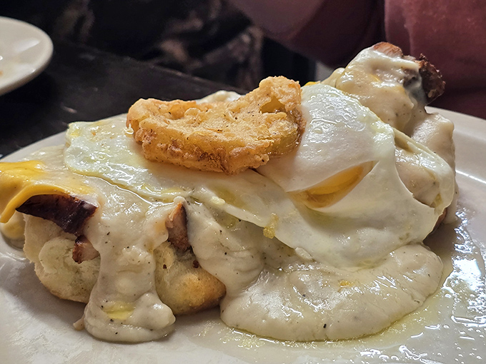 Sausage gravy cascading over tender biscuits like a delicious avalanche of Southern hospitality and pure breakfast magic happening.