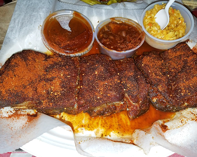 Dry-rubbed ribs in all their spice-crusted glory. That distinctive orange-red coating isn't just color &ndash; it's a flavor force field.