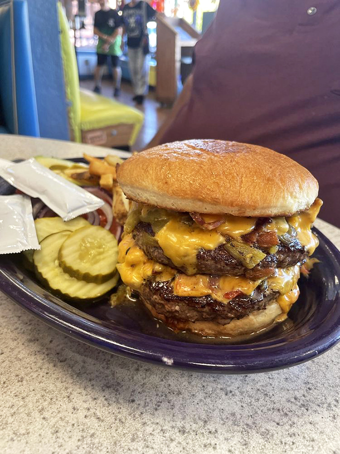 This isn't just a burger &ndash; it's a towering monument to excess with melted cheese cascading down like a yellow waterfall of joy.