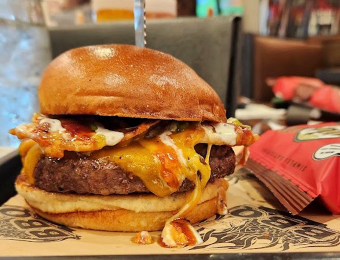 A burger that doesn't need a passport to travel between barbecue traditions. The melted cheese cascades like a yellow waterfall of joy.