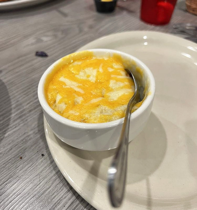 Cheesy grits that shine like liquid gold. Comfort in a cup that makes you understand why Southerners defend this dish with such passion.