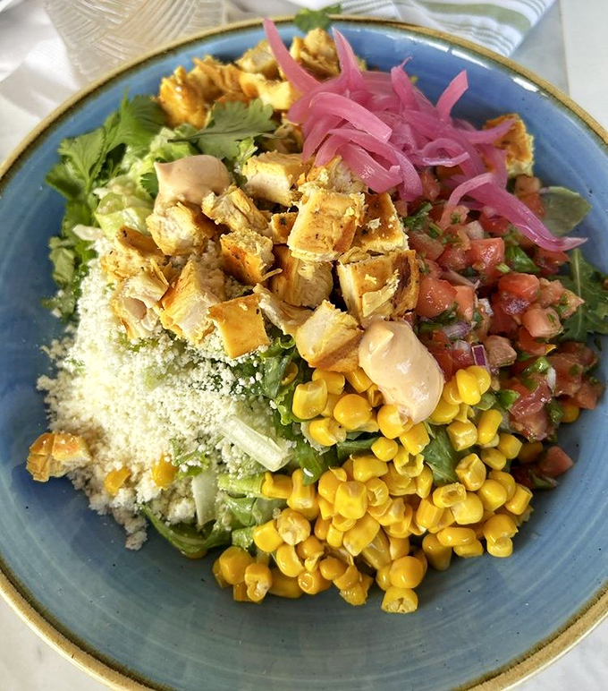 A colorful bowl that eats like a Miami sunset&mdash;bright corn, pink pickled onions, and protein playing together in perfect harmony.