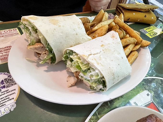 The wrap that launched a thousand road trips. Crisp lettuce, tender chicken, and a perfect tortilla hug &ndash; served with golden fries that demand to be stolen one by one.