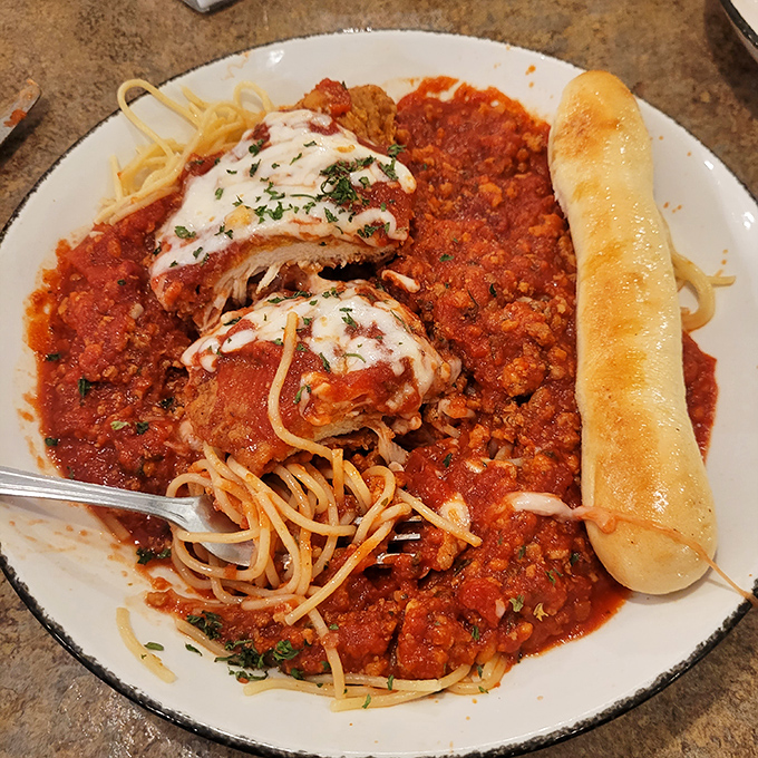 Chicken Parmesan that would make an Italian grandmother nod in approval, swimming in a sea of marinara with a breadstick standing by for sauce rescue missions.