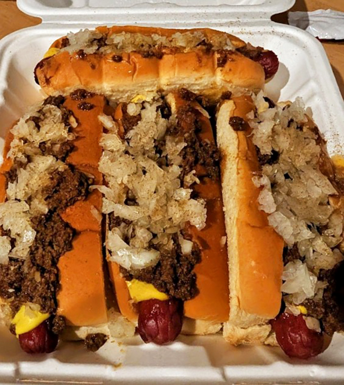 Chili dogs lined up like delicious soldiers, ready to wage war on midnight hunger with weapons of meat sauce, mustard, and onions.