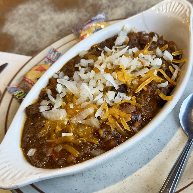Comfort in a bowl! This hearty chili topped with melted cheese and diced onions is what rainy Hilo days were made for &ndash; soul-warming goodness that sticks to your ribs.