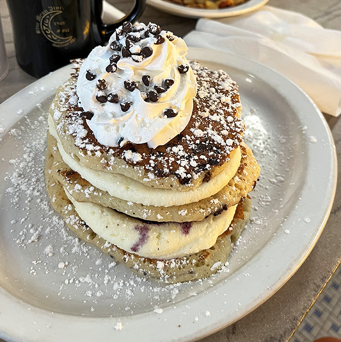Stack of pancakes or edible cloud formation? These fluffy discs topped with whipped cream and chocolate chips blur the line between breakfast and dessert.