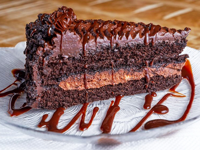 This chocolate layer cake isn't just dessert; it's therapy on a plate, with chocolate sauce drizzled like an abstract expressionist painting.