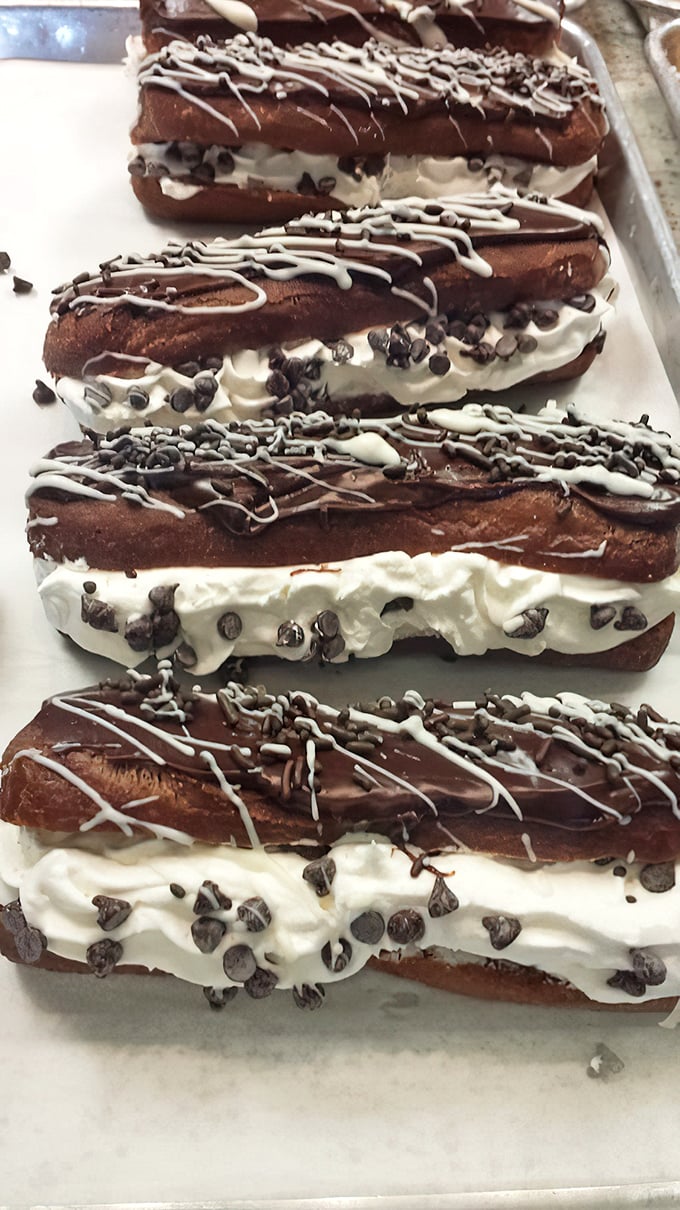 Chocolate eclairs stuffed with whipped cream and sprinkled with chocolate chips prove that excess can be beautiful.