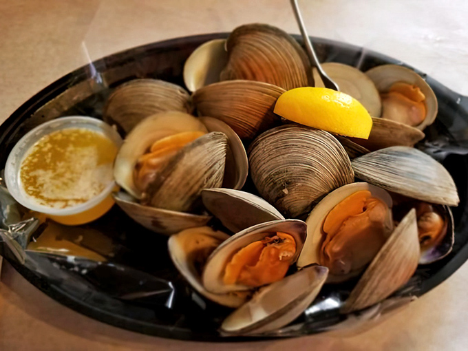 These steamed clams look like they're having a pool party in their own juices, with a lemon wedge ready to join the festivities.