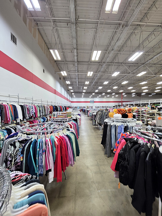 A rainbow of previously-loved garments hangs in perfect formation, like a textile army ready for inspection.