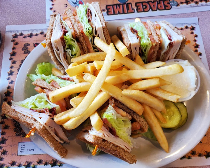 A club sandwich that stands taller than my childhood ambitions, layered with fresh ingredients between perfectly toasted bread.