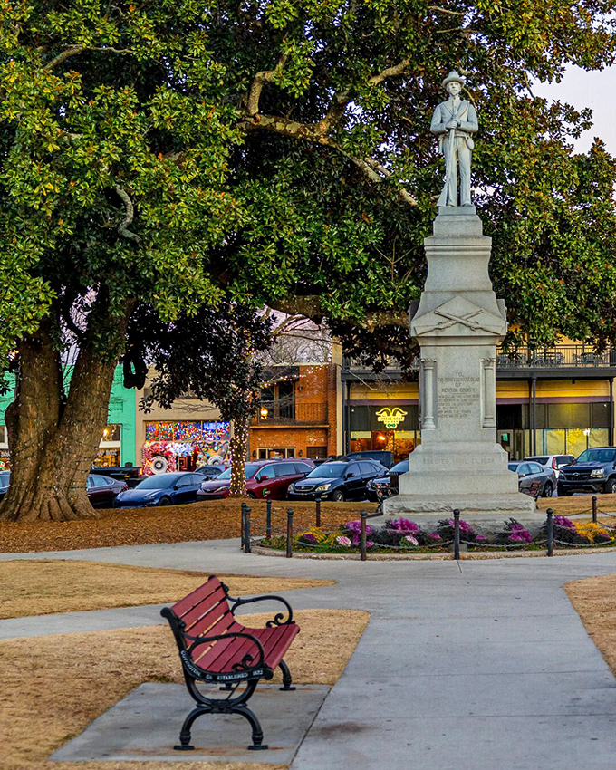 A quiet bench beneath ancient oaks offers perspective beside Covington's historic memorial, where present-day visitors contemplate the town's complex past.