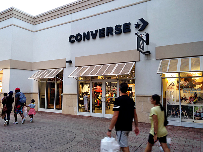 The Converse store glows like a beacon at dusk, drawing in shoppers for one last purchase before closing time.