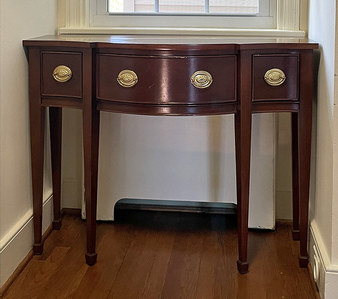 This elegant corner table with its curved front and brass hardware is the furniture equivalent of perfect posture. Grandma would definitely approve.