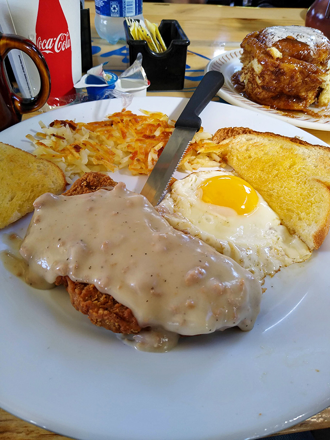 Country fried steak drowning in gravy with eggs and hash browns&mdash;breakfast doesn't negotiate, it just wins.