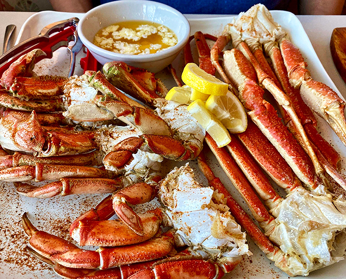 Snow crab legs arranged like nature's perfect eating puzzle. The bowl of melted butter isn't just a condiment&mdash;it's liquid gold for these treasures from the deep.