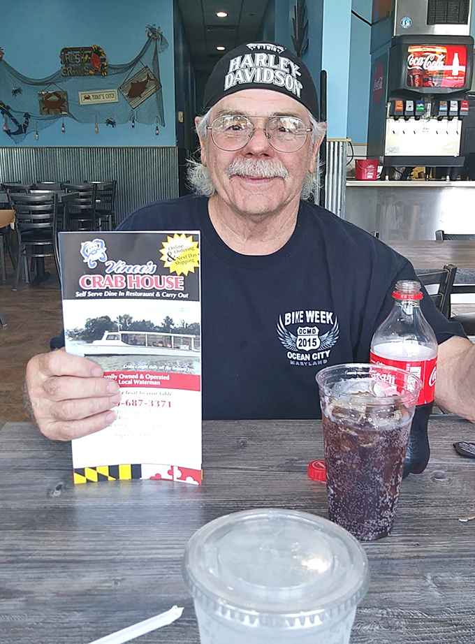 A satisfied customer shows off the menu&mdash;proof that in the religion of Maryland seafood, everyone's welcome to worship at this altar.