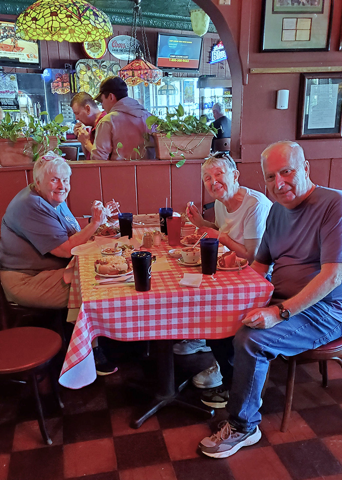Happy diners gathered around red checkered tablecloths&mdash;the universal signal that you're about to enjoy food that prioritizes flavor over pretension.