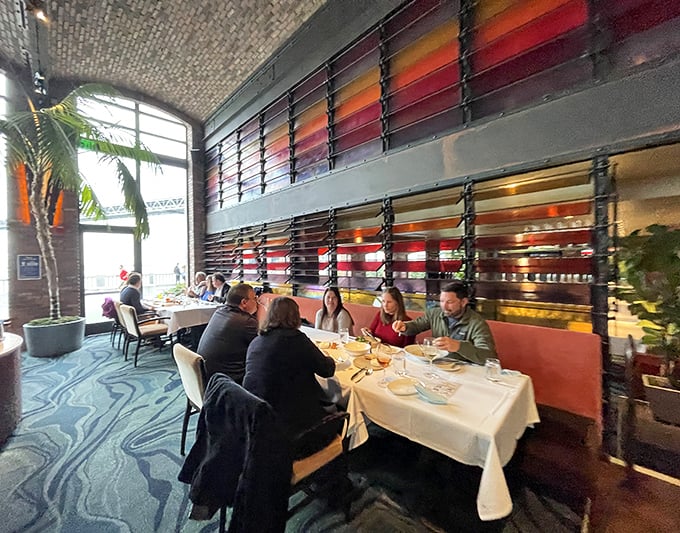 The dining room where conversations flow as smoothly as the wine, with those sunset-hued panels filtering light like nature's own Instagram effect.