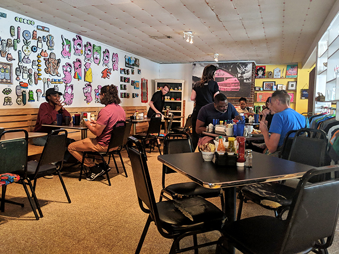 The dining room buzzes with the energy of happy eaters, colorful wall art, and the promise of memorable meals shared among friends.