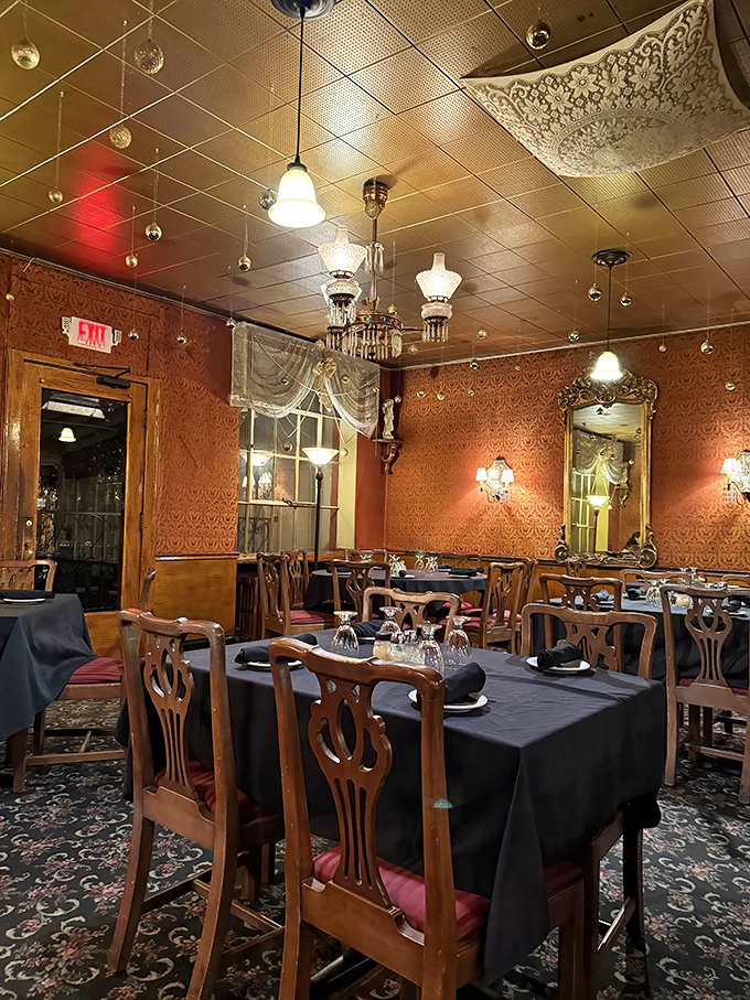 The dining room whispers of celebrations past with its ornate chandeliers, patterned wallpaper, and tables dressed in their formal best.