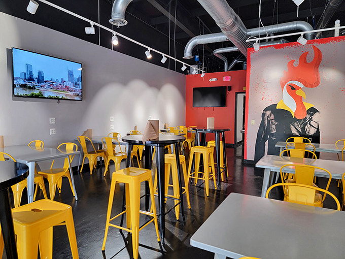 The dining area's vibrant yellow chairs pop against concrete floors, while a fiery chicken mural reminds you what you're here for.