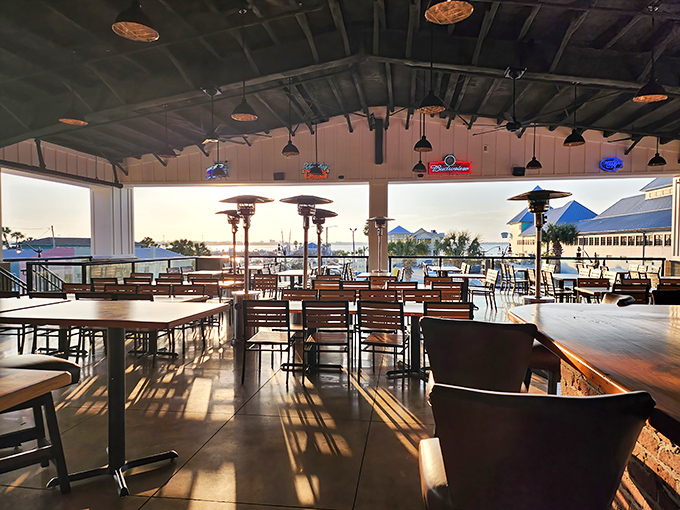The waterfront dining area offers views almost as delicious as the food, with golden hour light streaming through to highlight wooden simplicity.