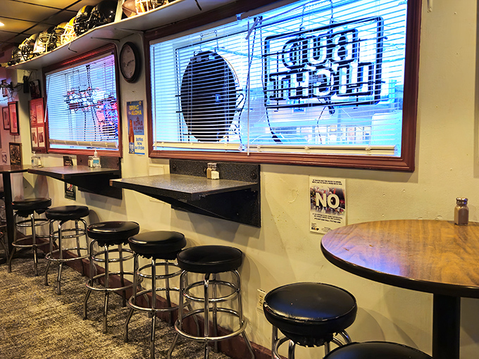 Classic bar seating where regulars have worn their loyalty into the stools, beneath the glow of neon beer signs.