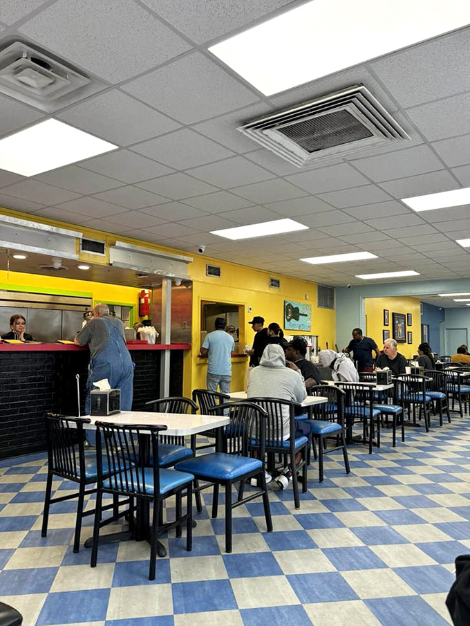 The dining area buzzes with anticipation as patrons line up for their breakfast fix. Those blue chairs have supported generations of satisfied customers.