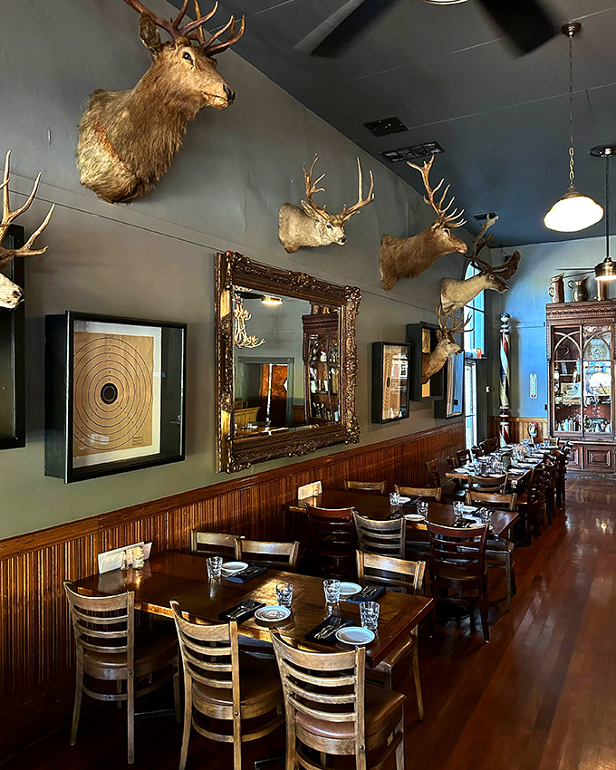 Blue walls adorned with trophy mounts create a dining room that feels like a sophisticated hunting lodge. Tables set with care await the next round of hungry adventurers.