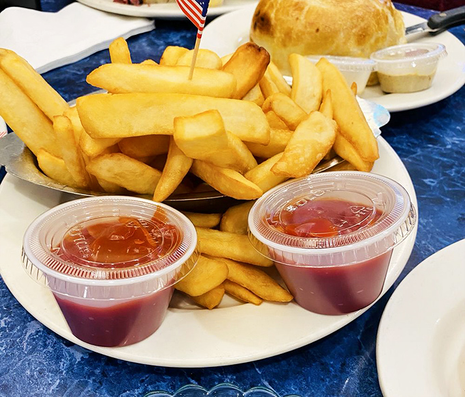 French fries so perfectly golden they deserve their own tiny American flags, accompanied by dipping sauces that demand equal attention.