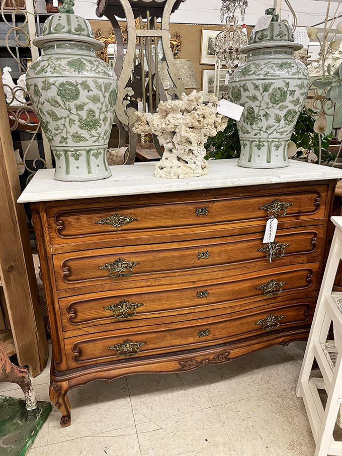 This marble-topped dresser once graced someone's boudoir, witnessing decades of morning routines and evening whispers.