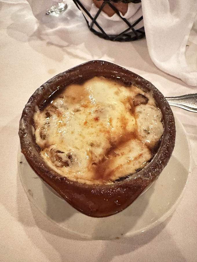French onion soup done right—a bubbling cauldron of comfort topped with a cheese cap that stretches with each spoonful.