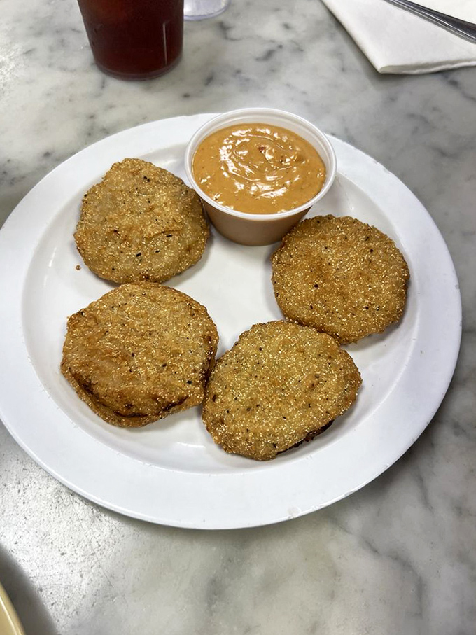 Fried green tomatoes&mdash;tangy slices wearing crunchy golden jackets, ready to dip into that creamy sauce like they're heading to a Southern pool party.