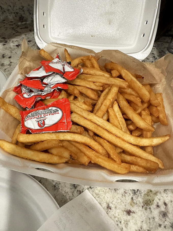 French fries piled high with enough ketchup packets to paint the town red, literally and figuratively speaking.