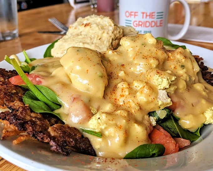 Breakfast reimagined: a mountain of goodness smothered in golden gravy with fresh greens providing a pop of color and nutritional alibi.